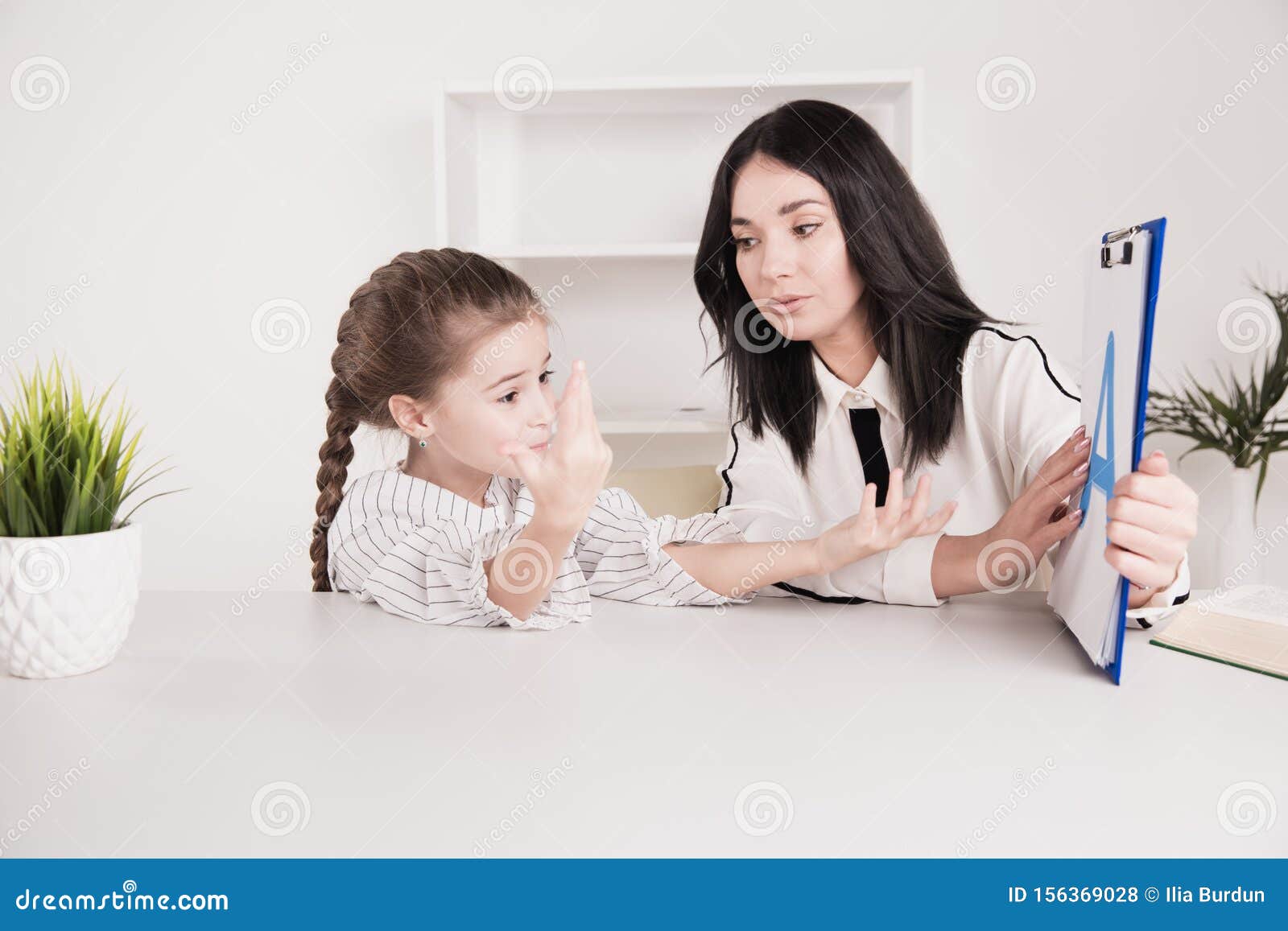 Teacher and Litle Girl Working on a Pronunciation Together in the Class ...
