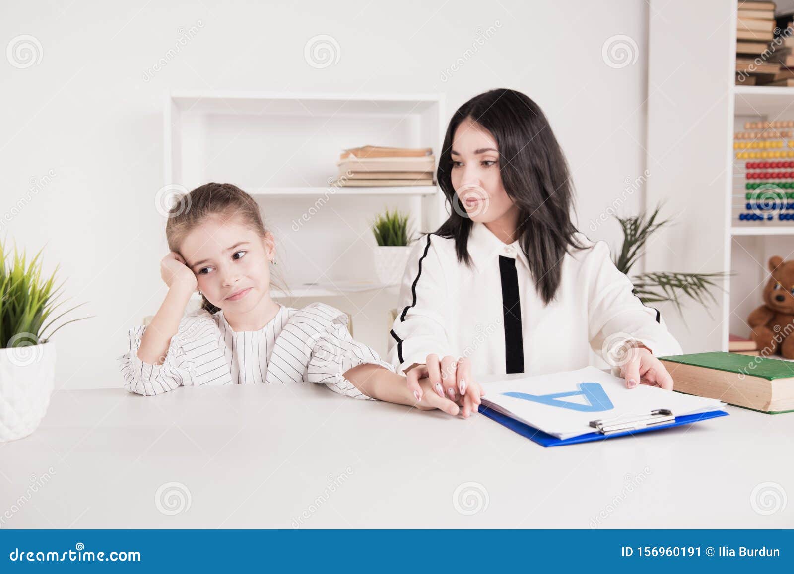 Teacher and Litle Girl Working on a Pronunciation Together in the Class ...
