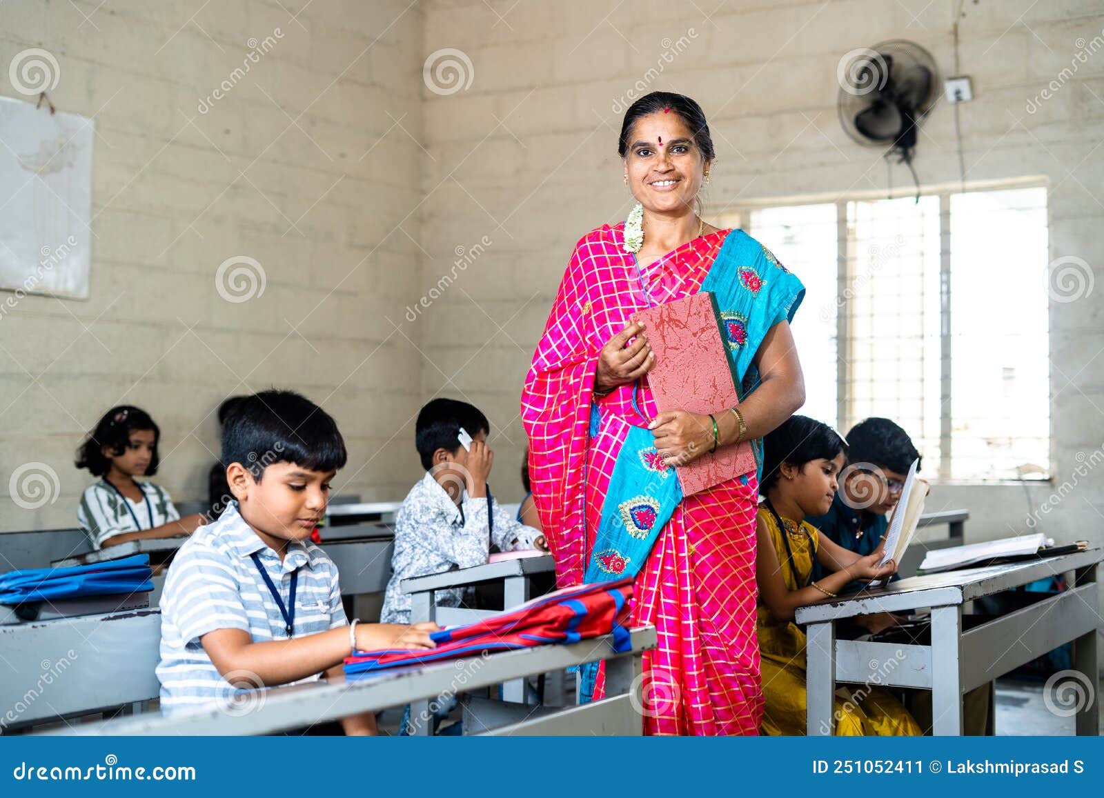 Teacher Looking at Camera while Teaching To Elementary School Students ...