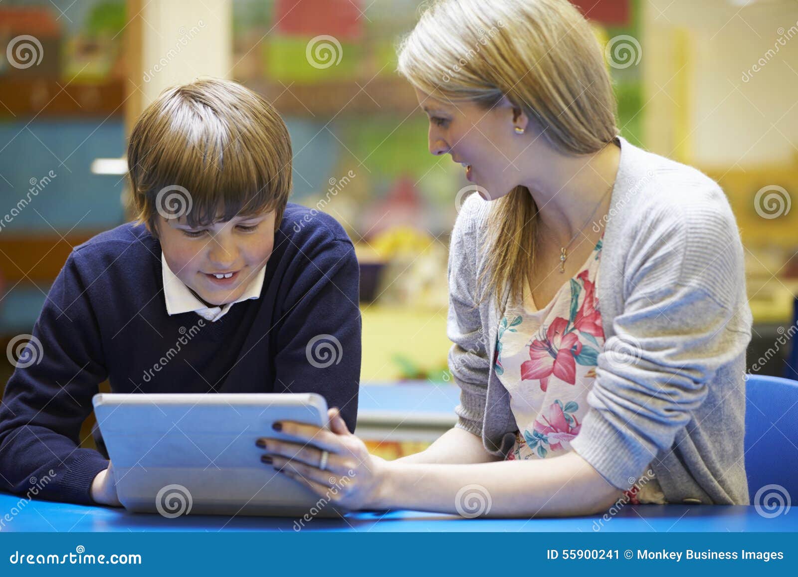 Teacher with Male Pupil Using Digital Tablet in Classroom Stock Image ...