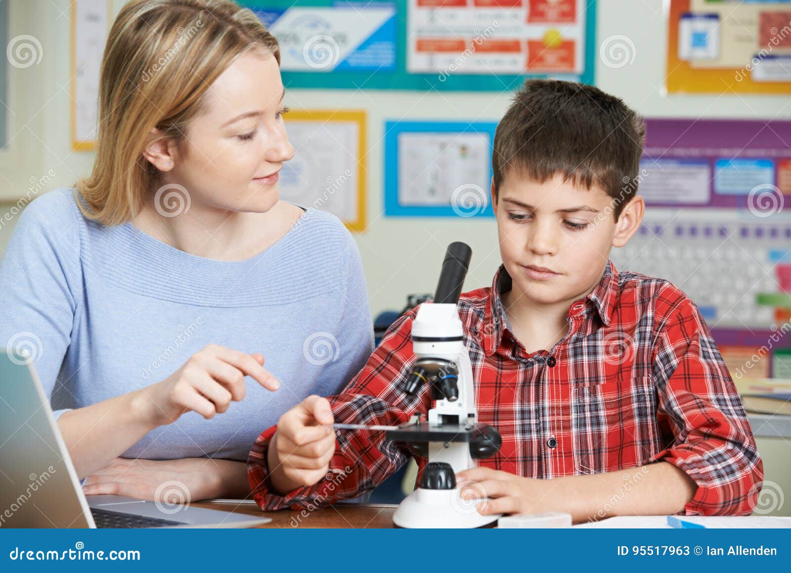 Teacher with Male Student Using Microscope in Science Class Stock Image ...