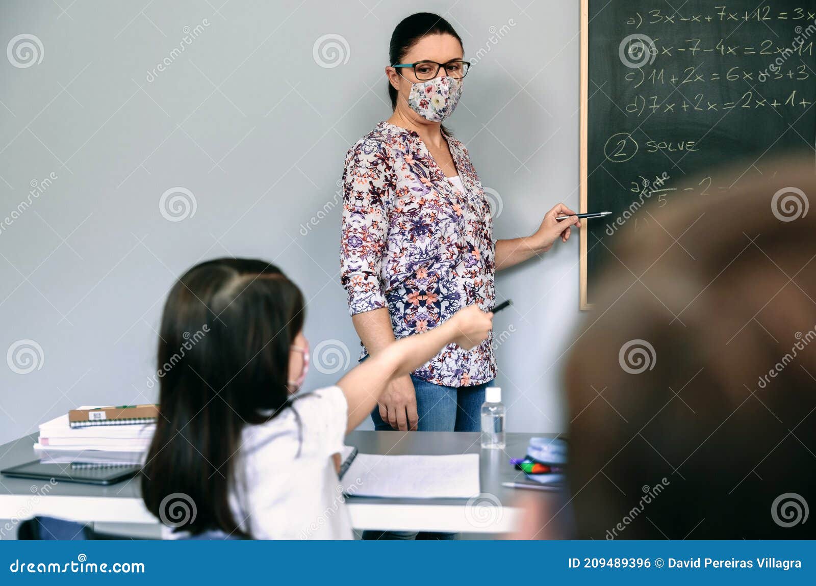 Teacher with Mask Explaining Exercises in Math Class Stock Photo ...