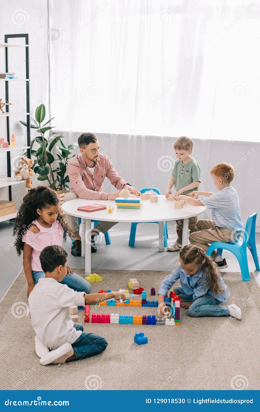 Teacher and Multicultural Preschoolers on Floor with Colorful Bricks ...
