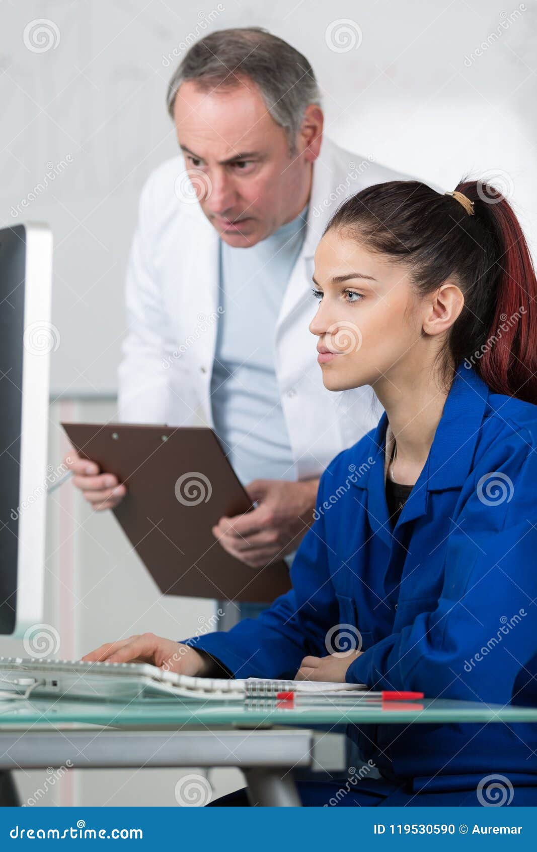 Teacher Overseeing Student Working on Computer Stock Photo - Image of ...