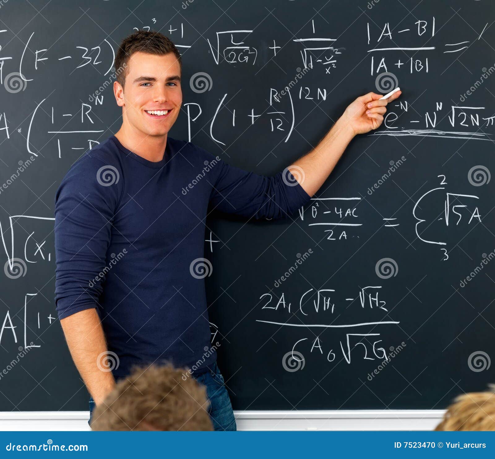 Stock Photo: Teacher pointing at blackboard teaching math. Image: 7523470