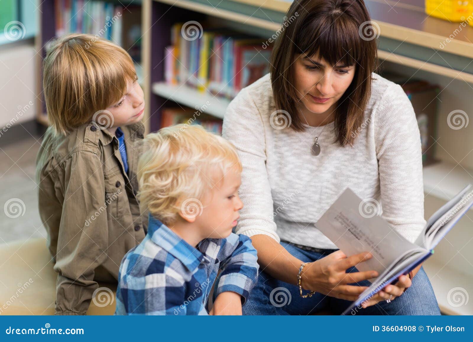 Teacher Reading Book for Students in Library Stock Photo - Image of ...