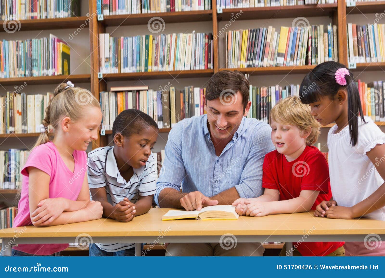 Teacher Reading Book To Pupils at Library Stock Photo - Image of ...