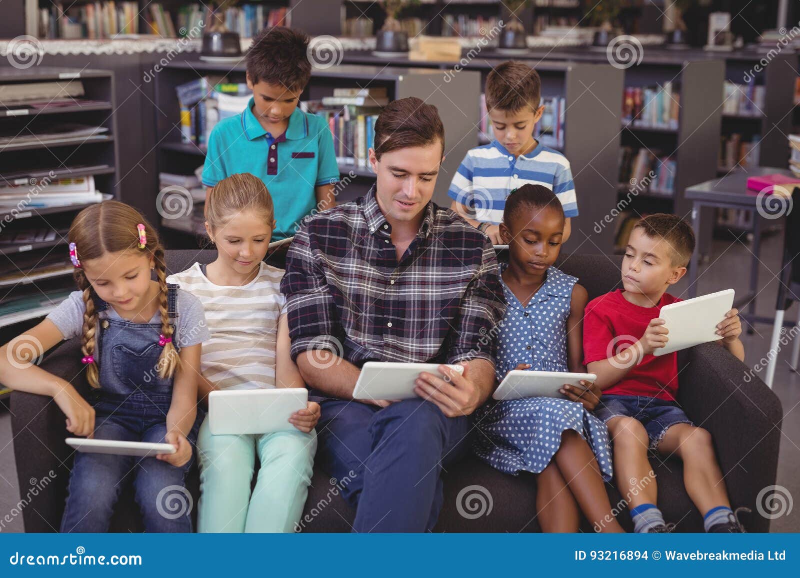 Teacher and Schoolkids Using Digital Tablet in Library Stock Photo ...