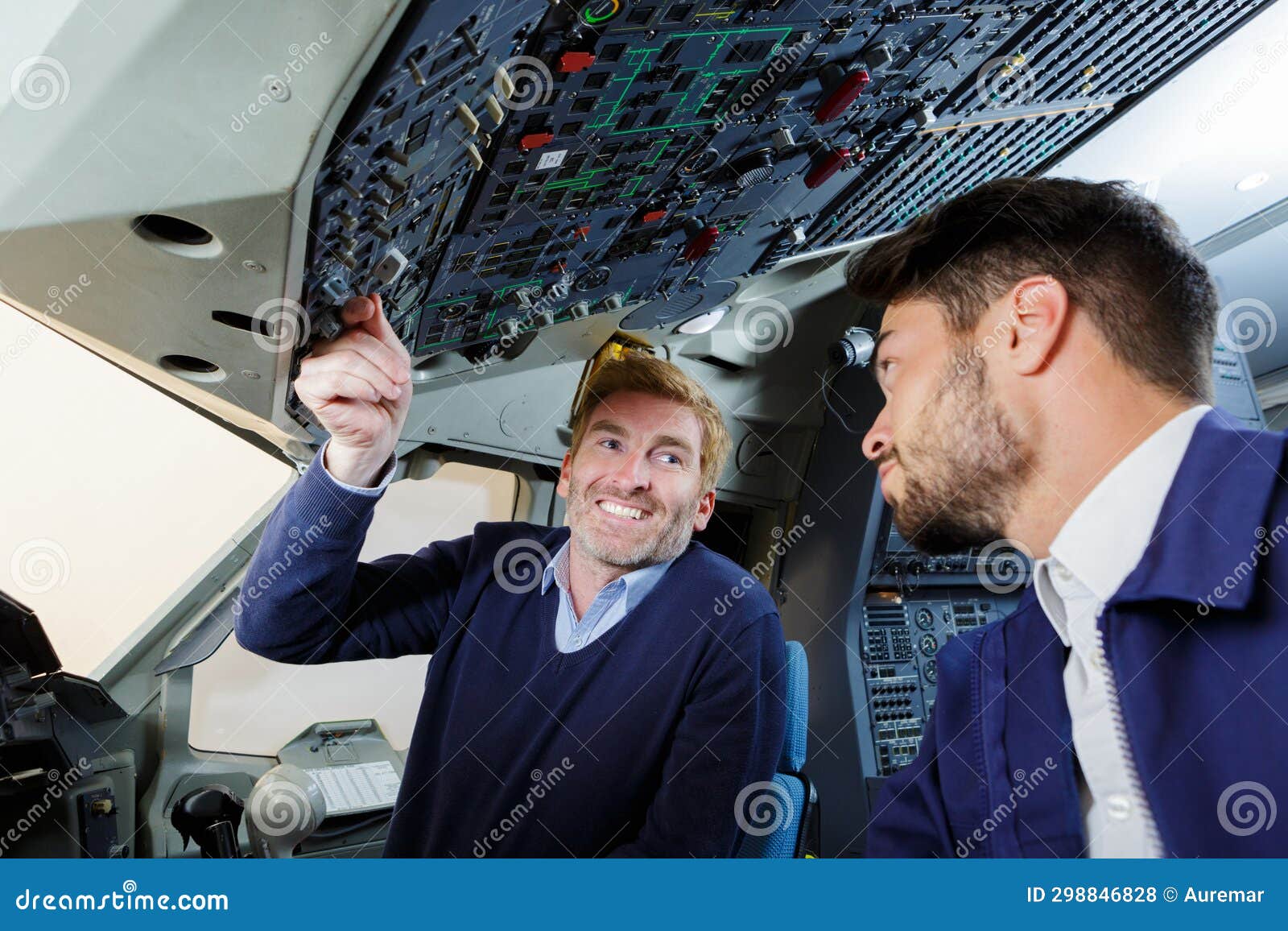 Teacher Showing Apprentice Overhead Controls in Aircraft Cockpit Stock ...