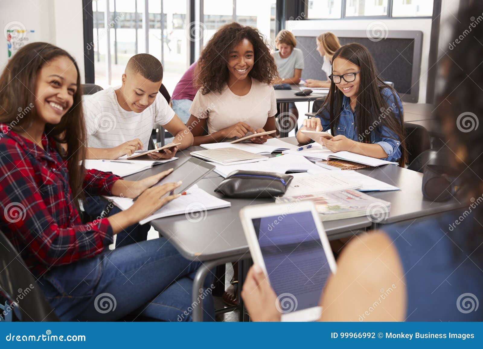 Teacher Sitting with High School Students Using Tablets Stock Photo ...