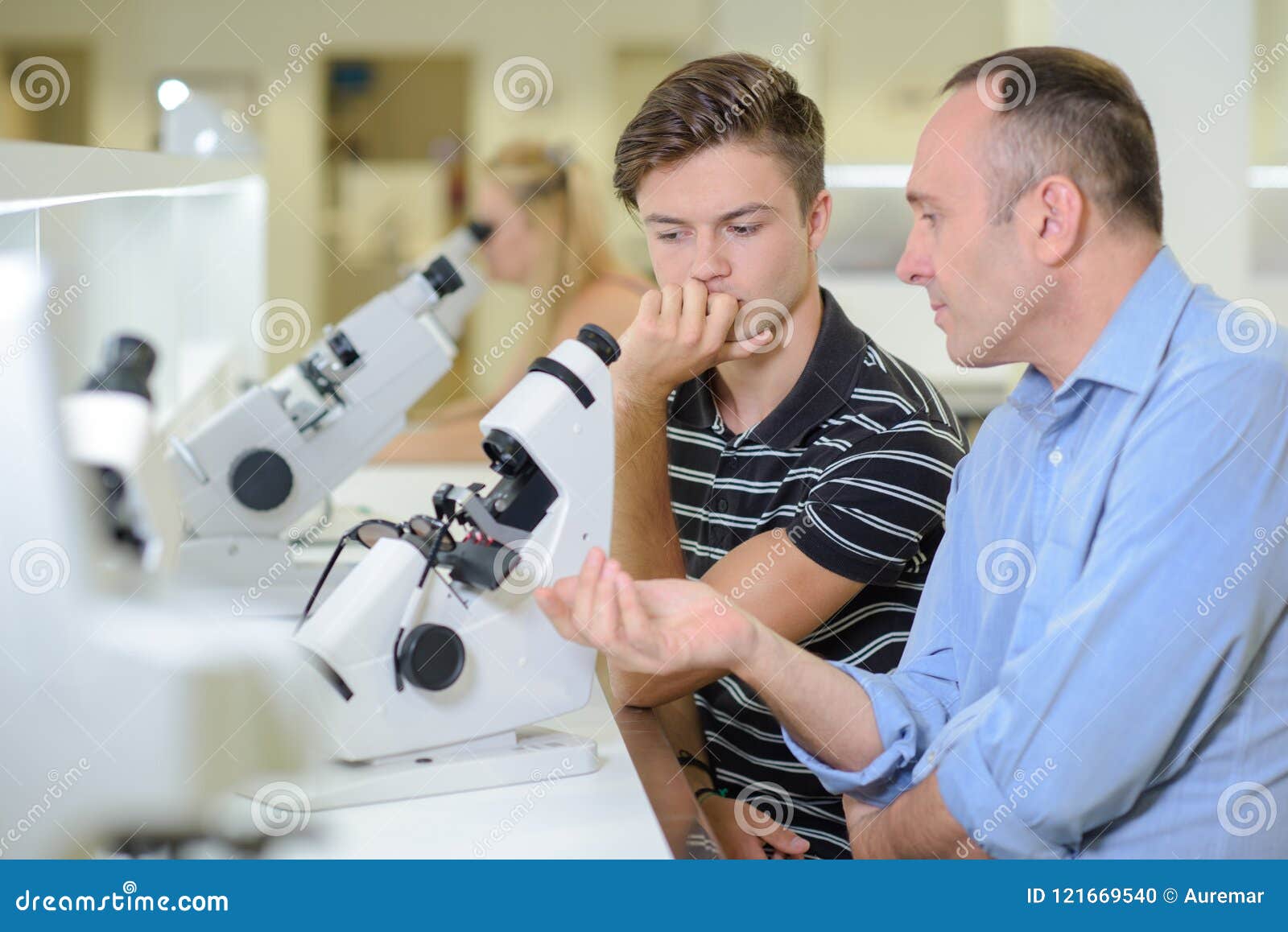 Teacher with Student at Microscope Stock Photo - Image of equipment ...