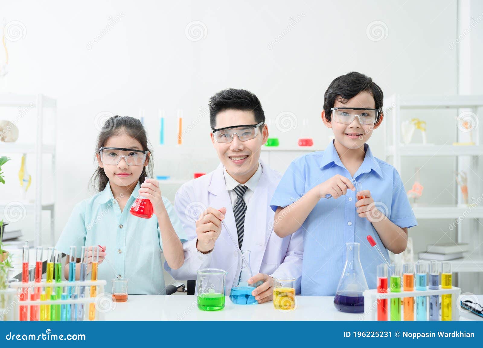 Teacher and Students are Looking at the Camera while Doing Science ...