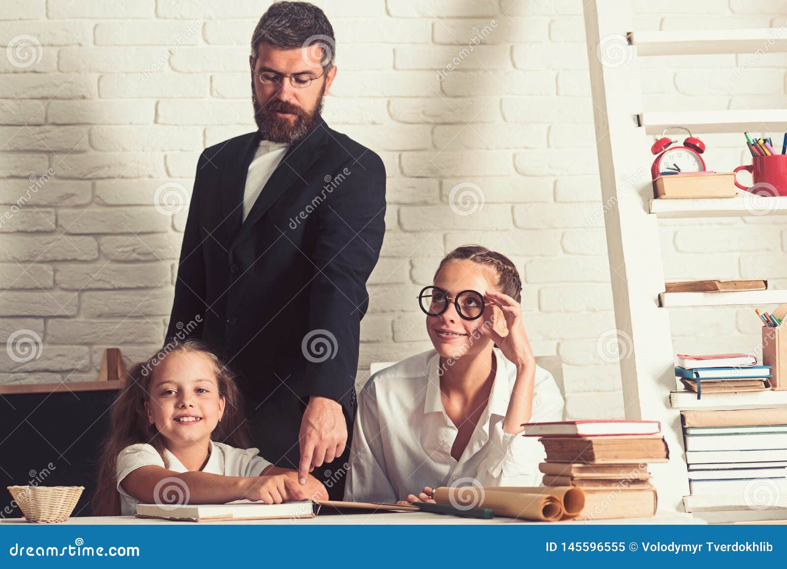 Teacher Studying School Books in Class with Primary School Kids. Stock ...