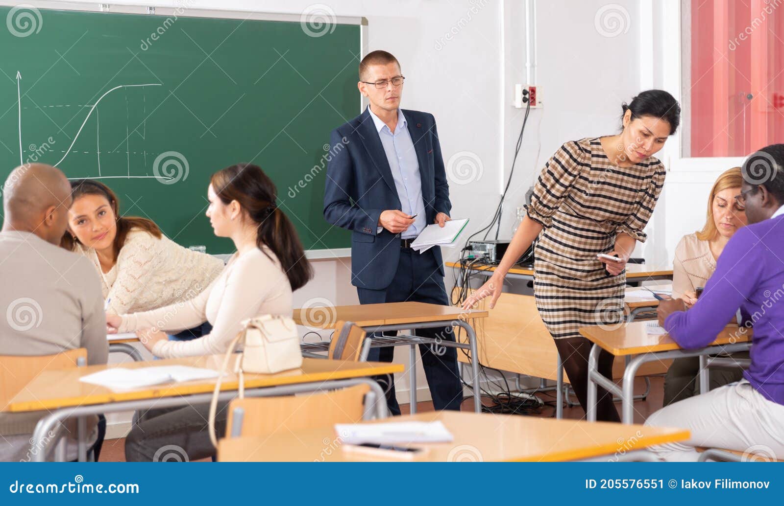 Teacher Supervising Work of Students in Groups in Classroom Stock Image ...
