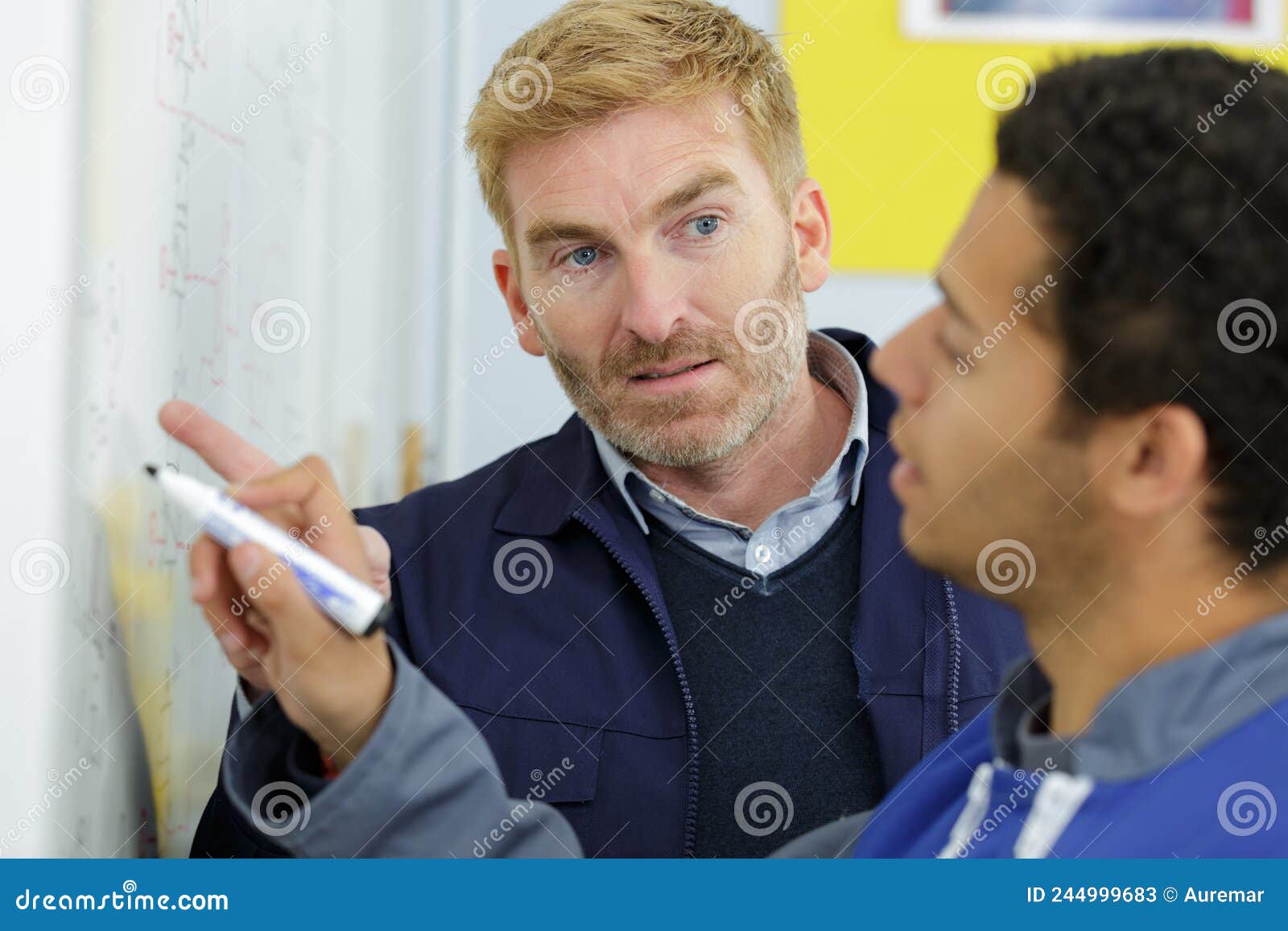Teacher Talking To Apprentice Engineer Writing on Whiteboard Stock ...