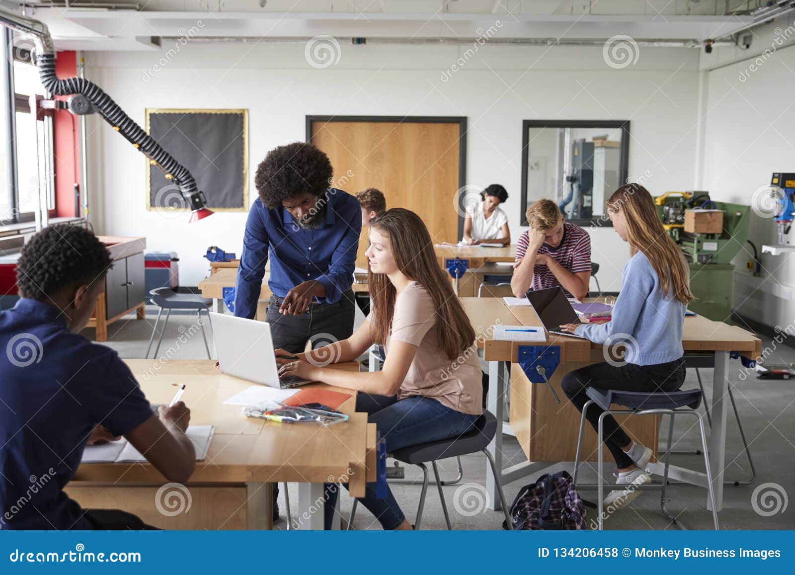 Teacher Talking To Female High School Student Sitting at Work Bench ...