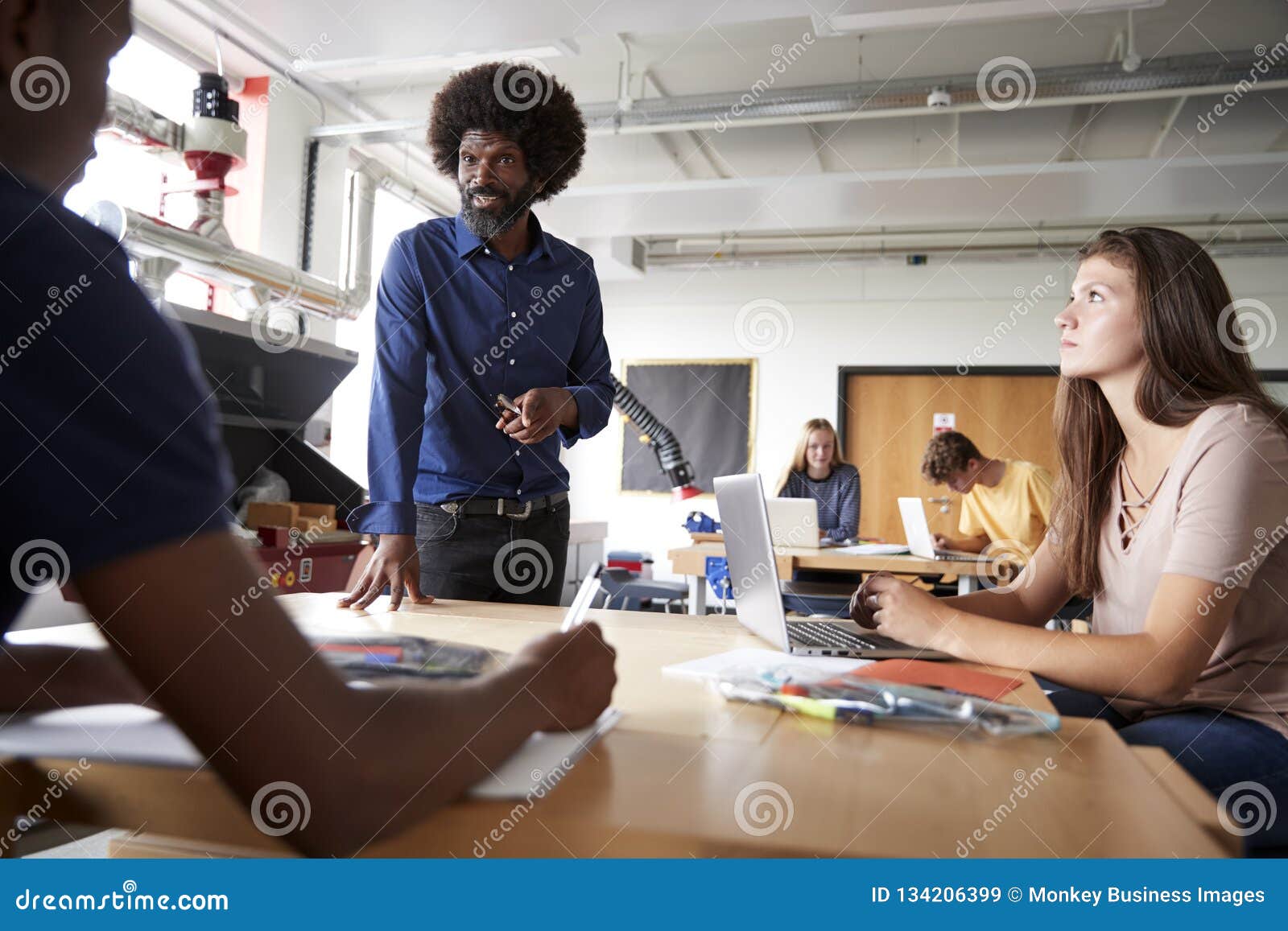 Teacher Talking To Group of High School Students Sitting at Work ...