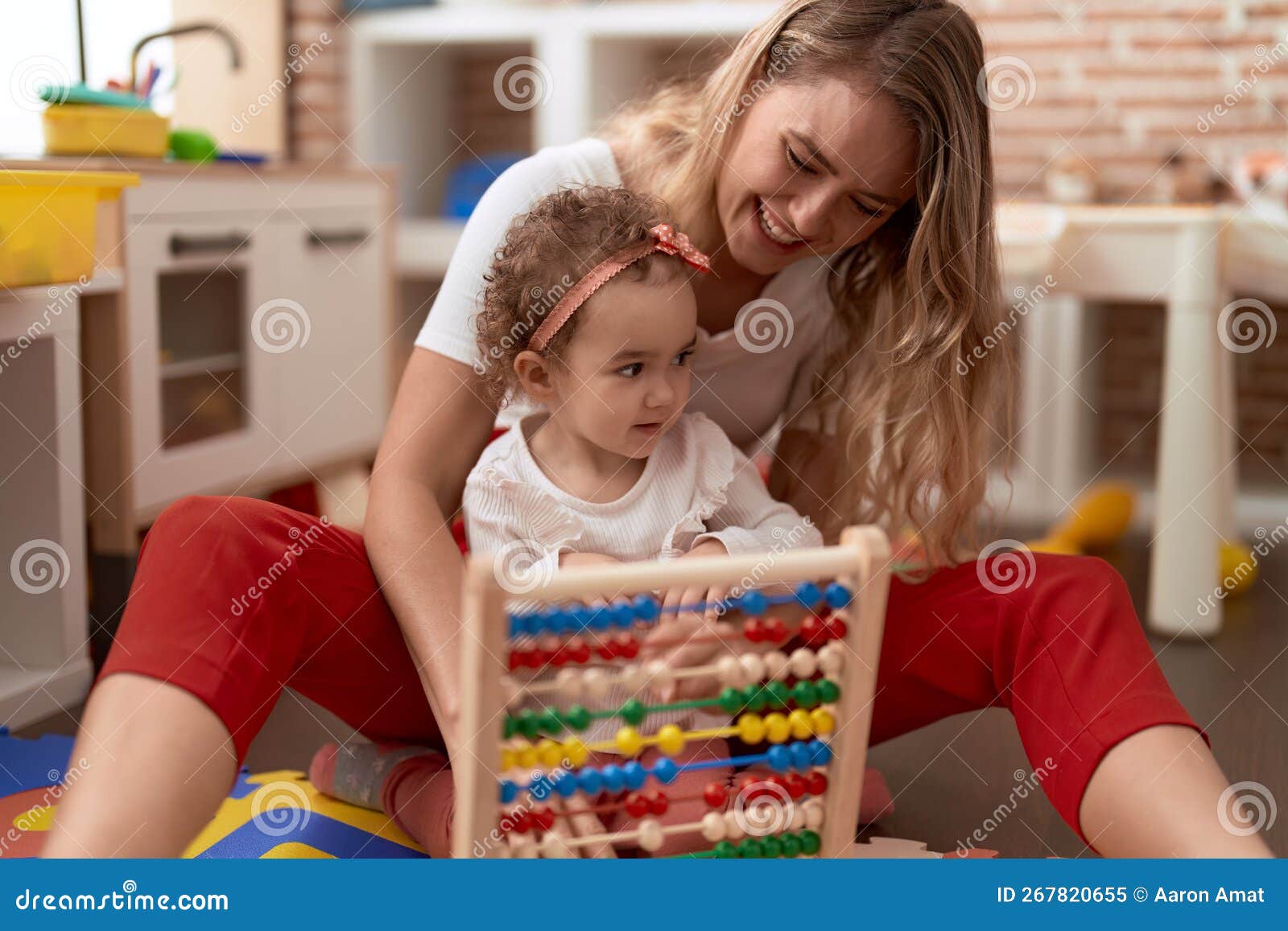 Teacher and Toddler Learning Maths with Abacus Sitting on Floor at ...