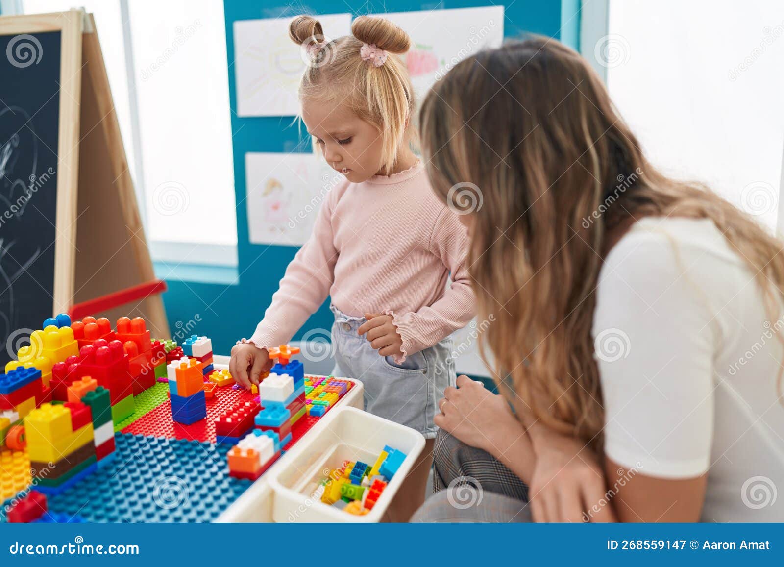 Teacher and Toddler Playing with Construction Blocks Sitting on Table ...