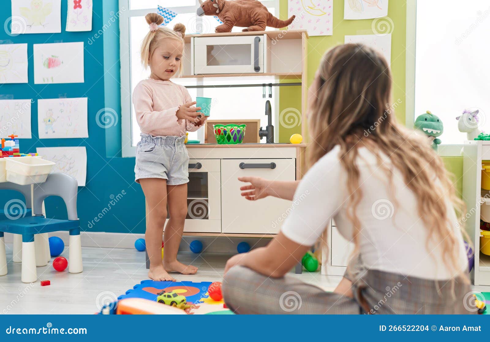 Teacher and Toddler Playing with Play Kitchen Standing at Kindergarten ...