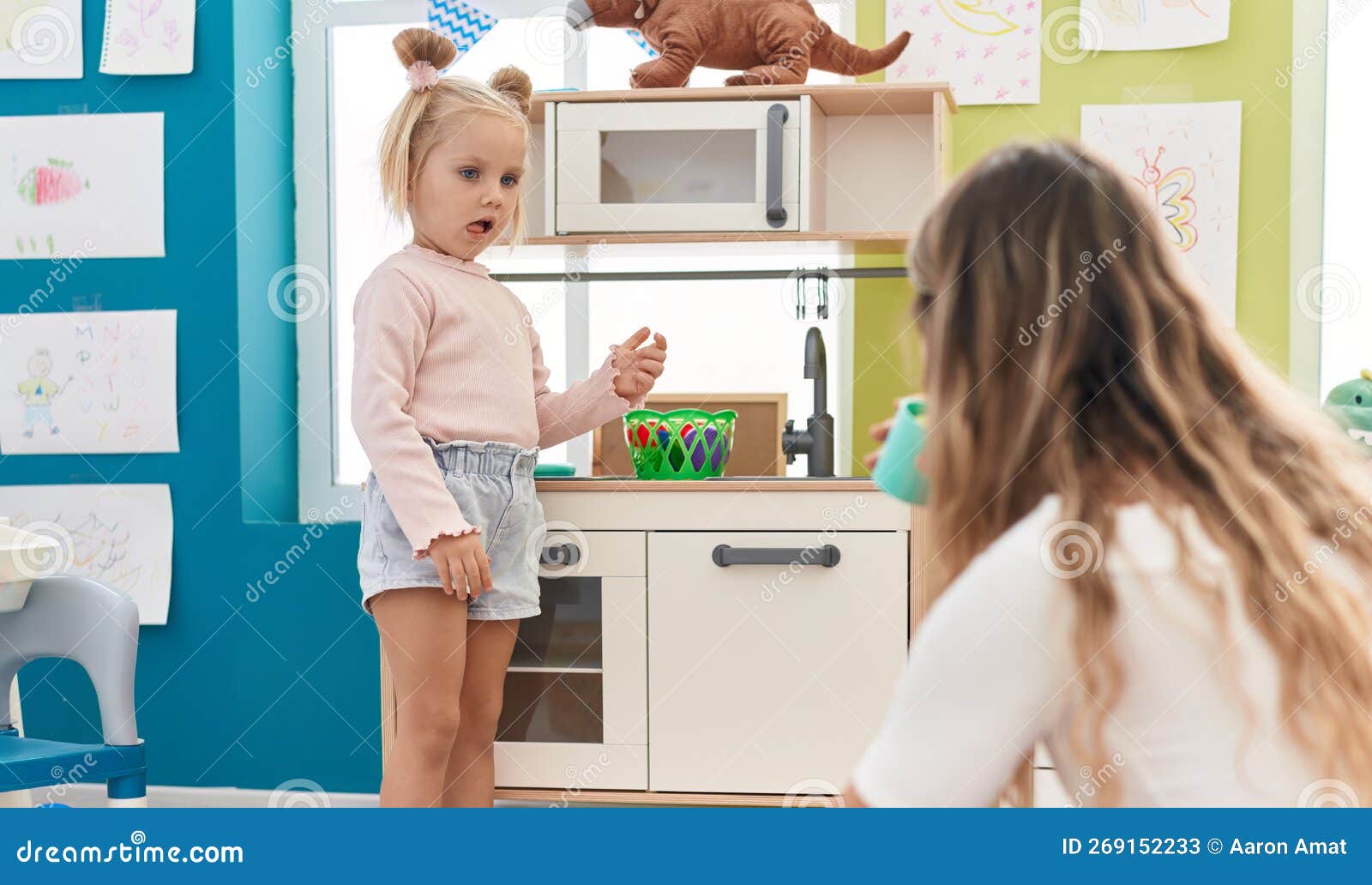Teacher and Toddler Playing with Play Kitchen Standing at Kindergarten ...