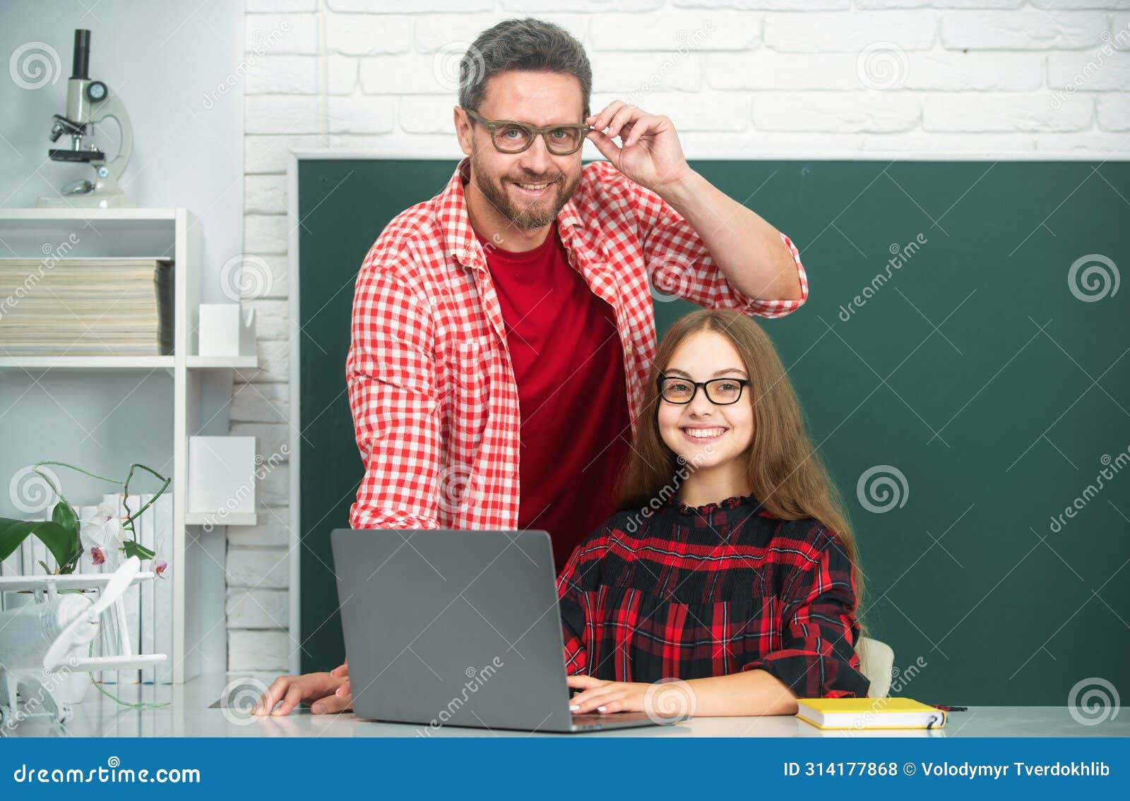 Teacher Tutor Helping School Child in Class at School Using Laptop ...