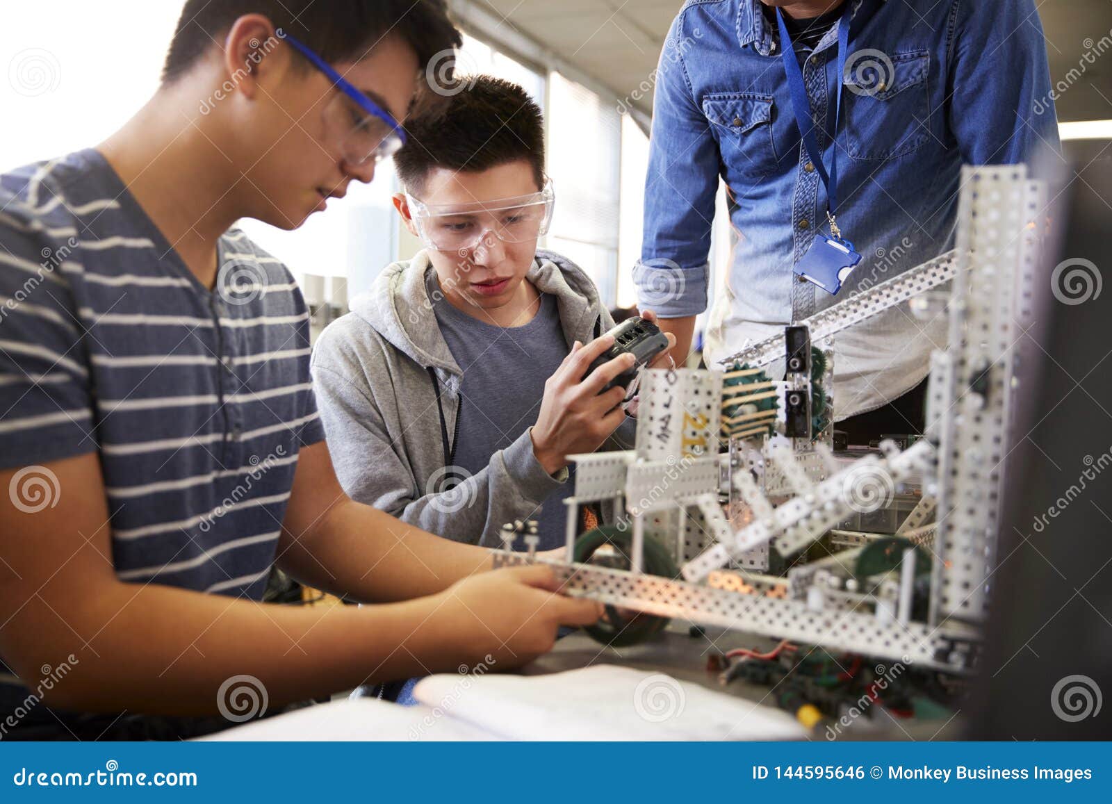 Teacher with Two Male College Students Building Machine in Science ...