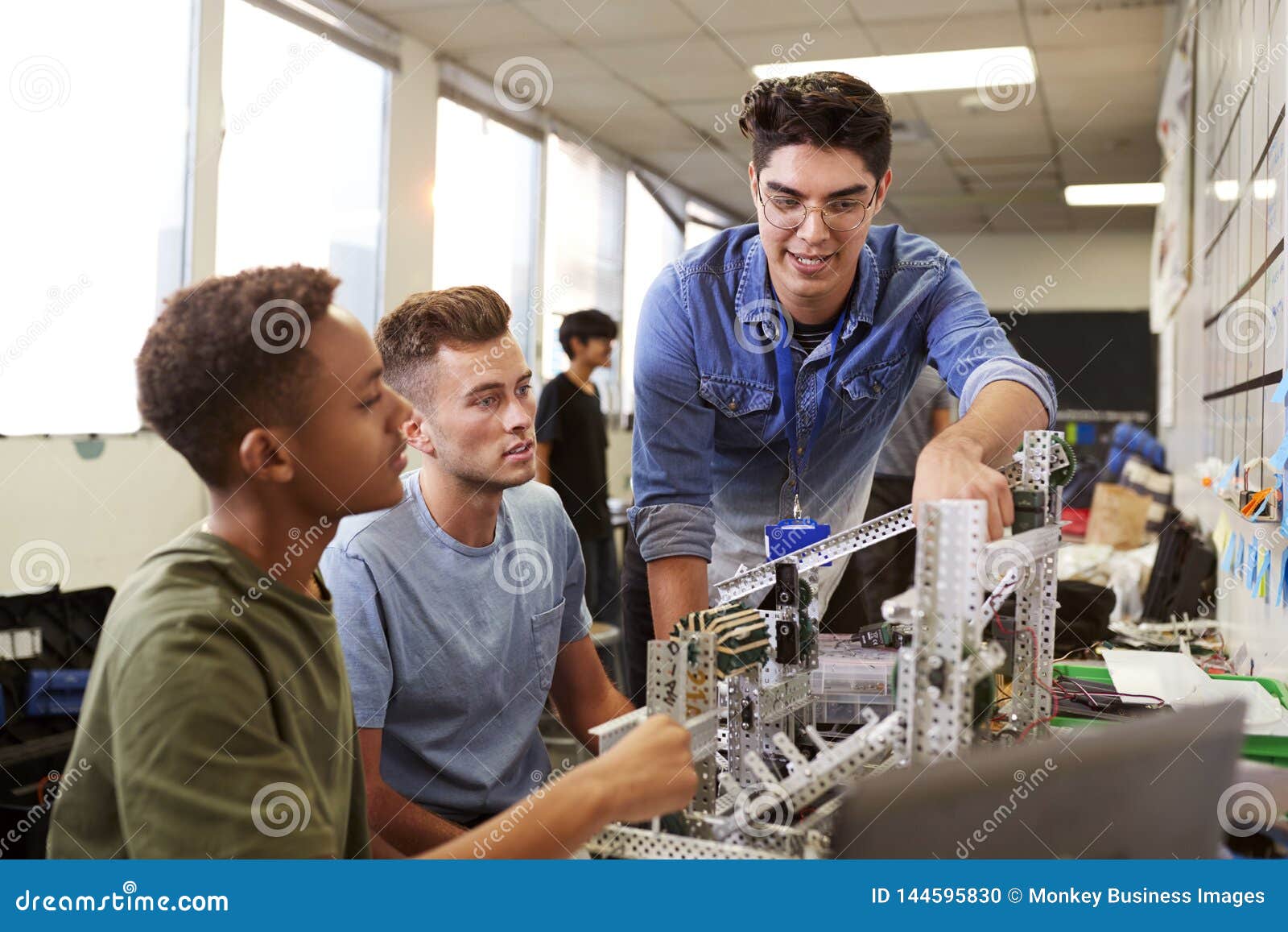 Teacher with Two Male University Students Building Machine in Science ...