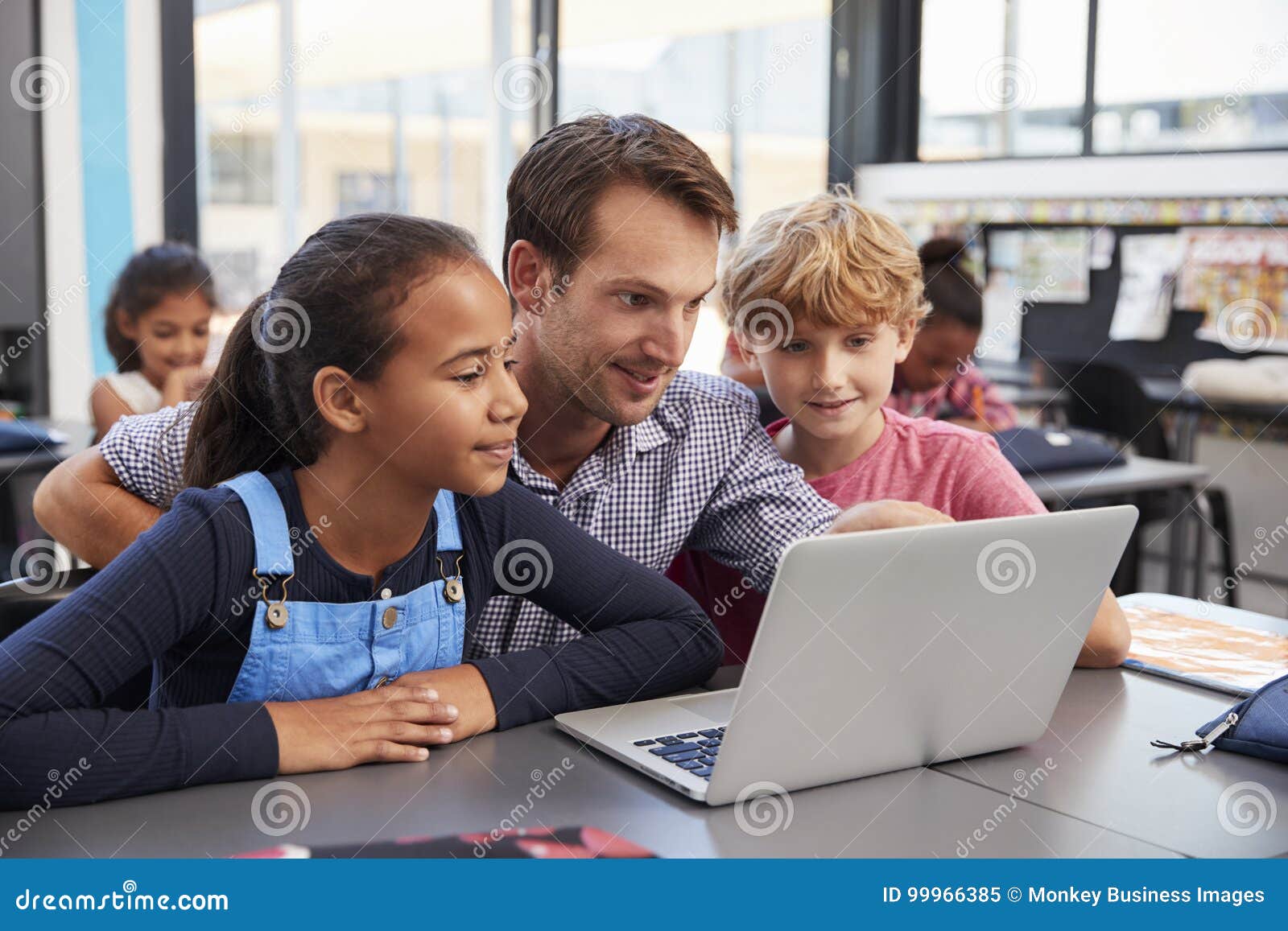 Teacher and Two Young Students Use Laptop Computer in Class Stock Image ...