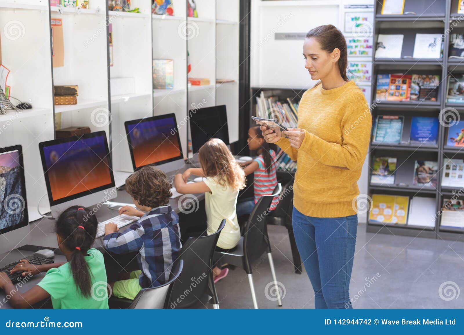 Teacher Using Digital Tablet in Computer Room Stock Photo - Image of ...