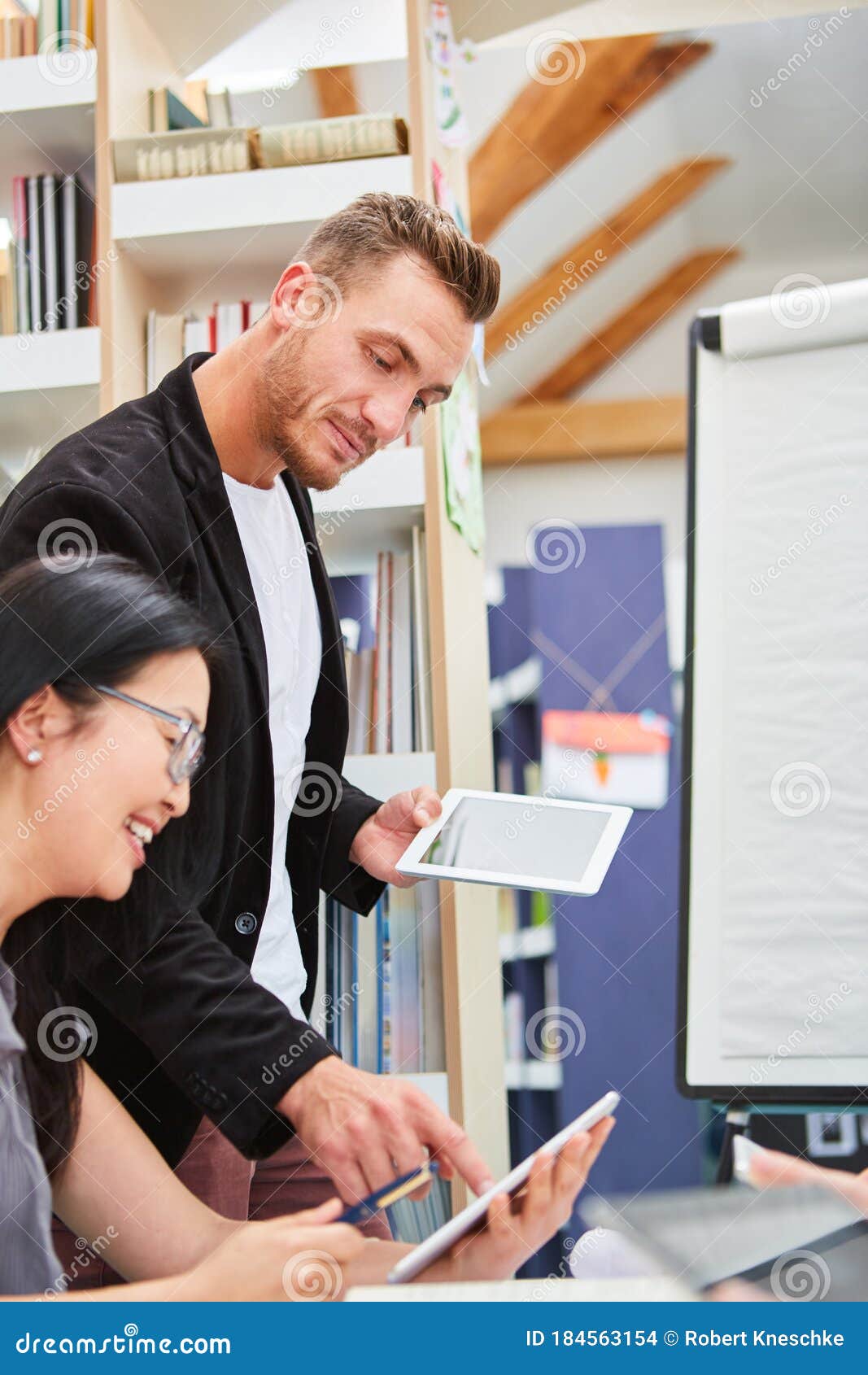 Teacher Using Tablet Computer Helps a Student Stock Photo - Image of ...