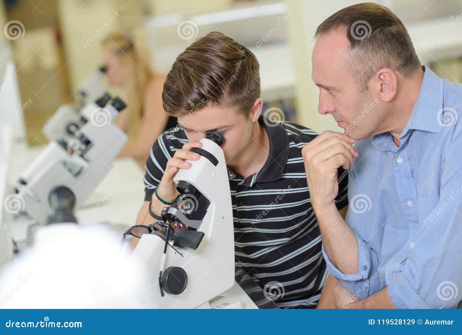 Teacher Watching Student Look into Microscope Stock Image - Image of ...