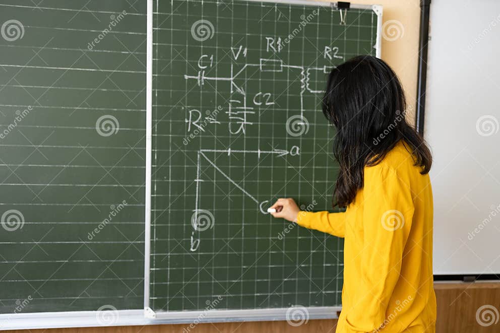 Teacher Write on the Blackboard and Explain a Lesson. Stock Photo ...