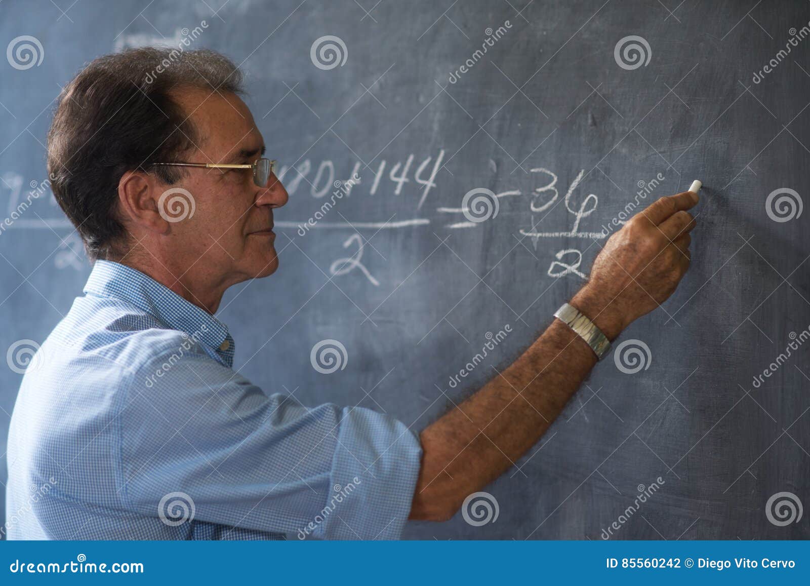 Teacher Writing Math Formulas on Blackboard at High School Stock Photo ...