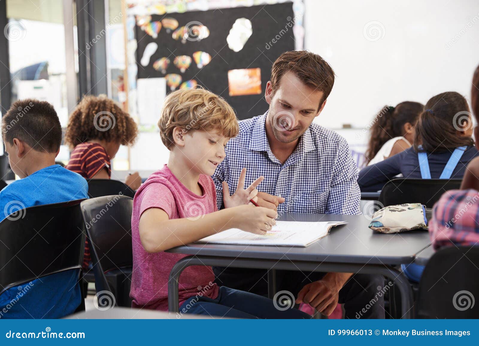 Teacher and Young School Boy Looking at Notebook in Class Stock Image ...
