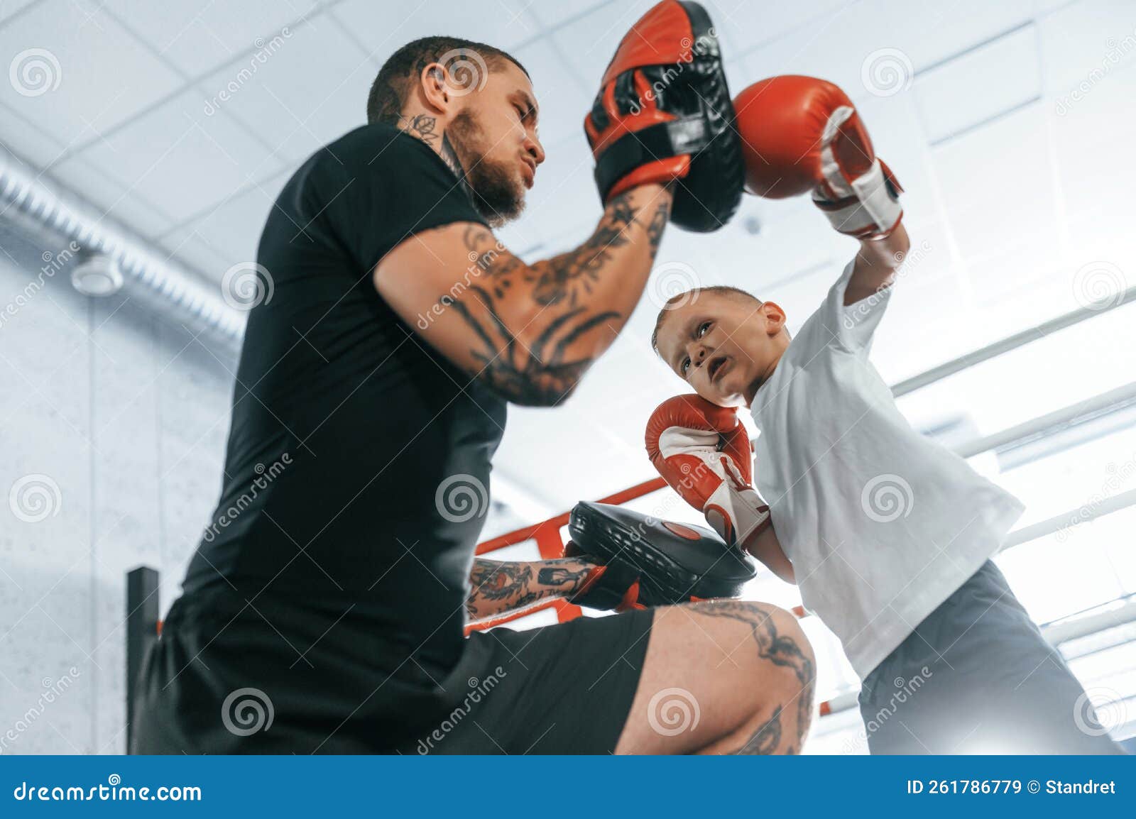 Teaching How To Punch. Coach is with Boy Showing Box Techniques Indoors ...
