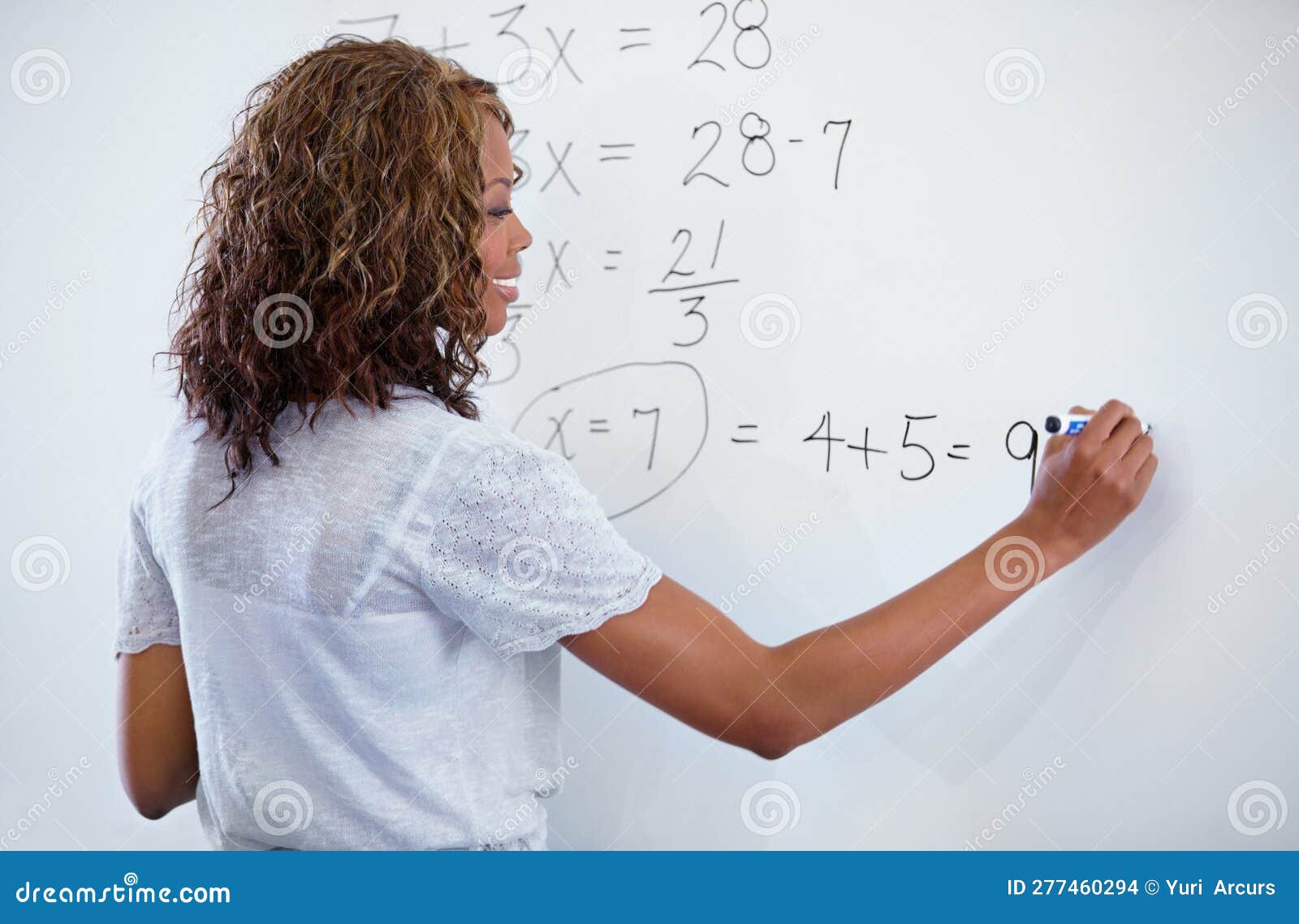 Teaching Maths. a Young Teacher Doing Maths Equations on the Whiteboard ...