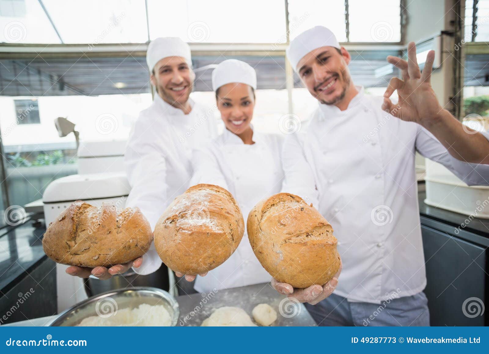 Team of Bakers Smiling at Camera Holding Bread Stock Image - Image of ...