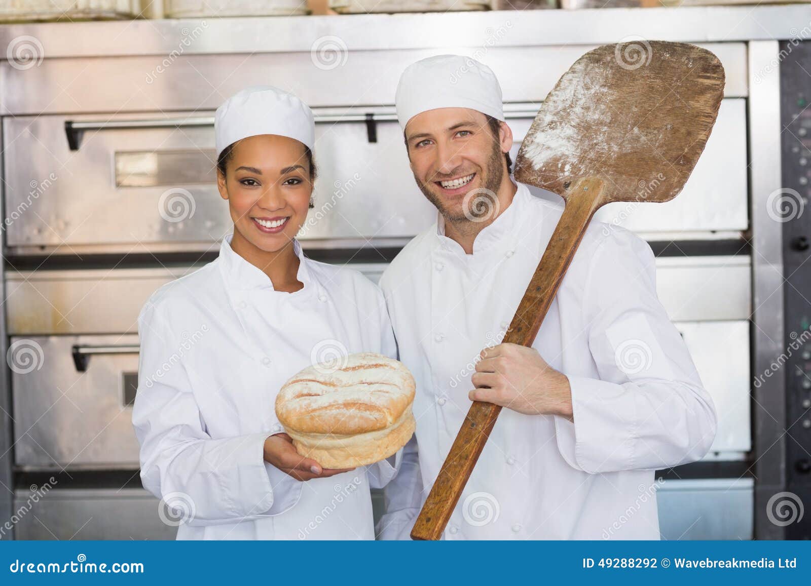 Team of Bakers Smiling at Camera with Loaf Stock Photo - Image of baker ...