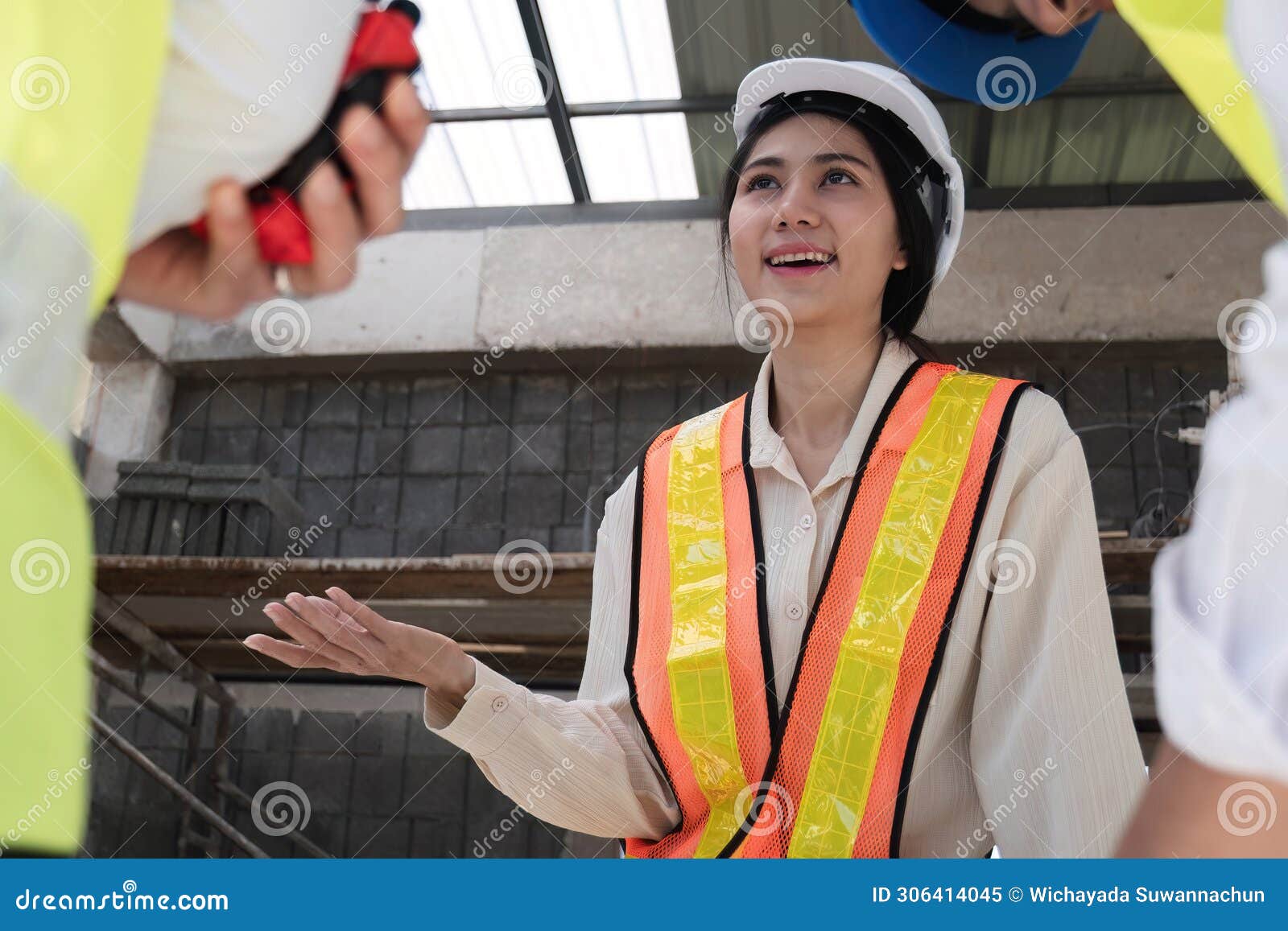 A Team of Civil Engineers and Foremen Discuss Construction Project Plans. Holding Project Plan ...