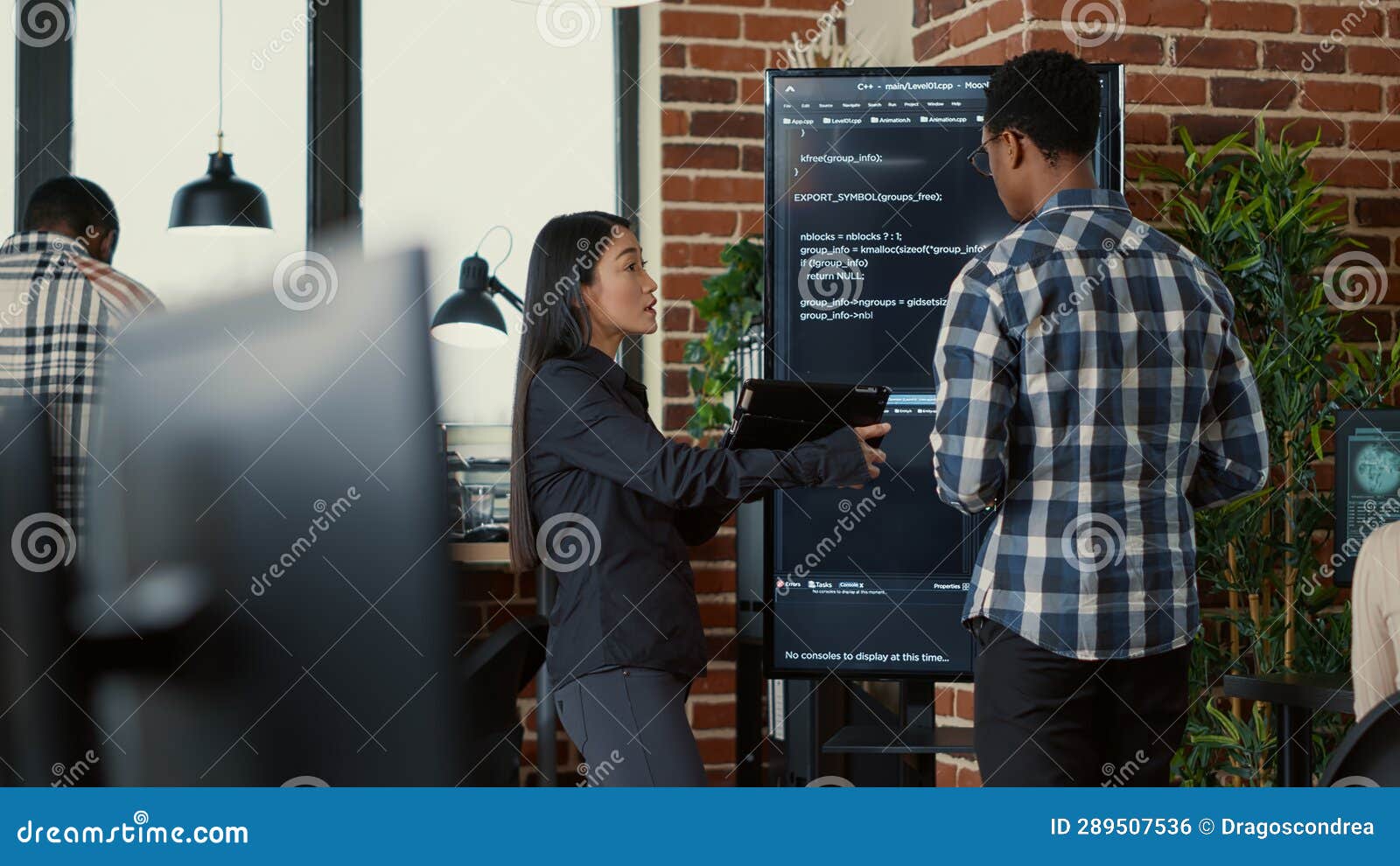 Team Of Coders Analyzing Code On Wall Screen Tv Comparing Errors Using