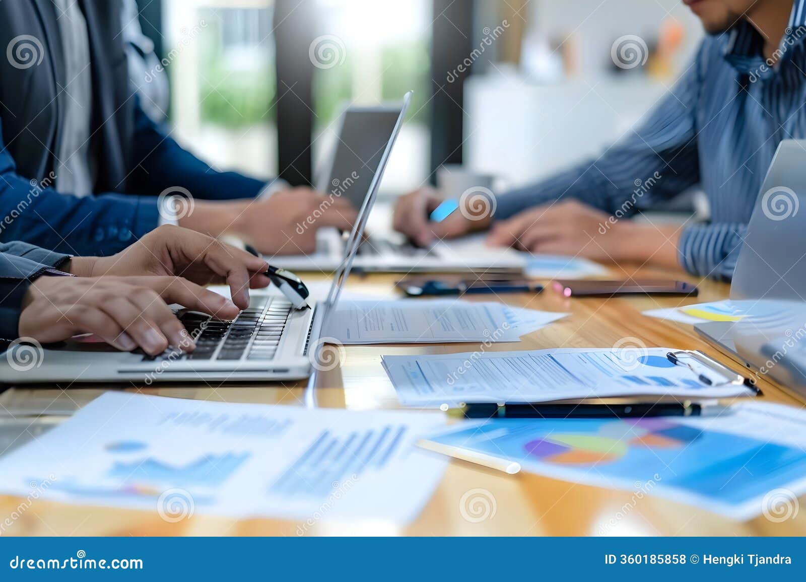 Team Collaborates on Project, Utilizing Laptops and Documents for ...