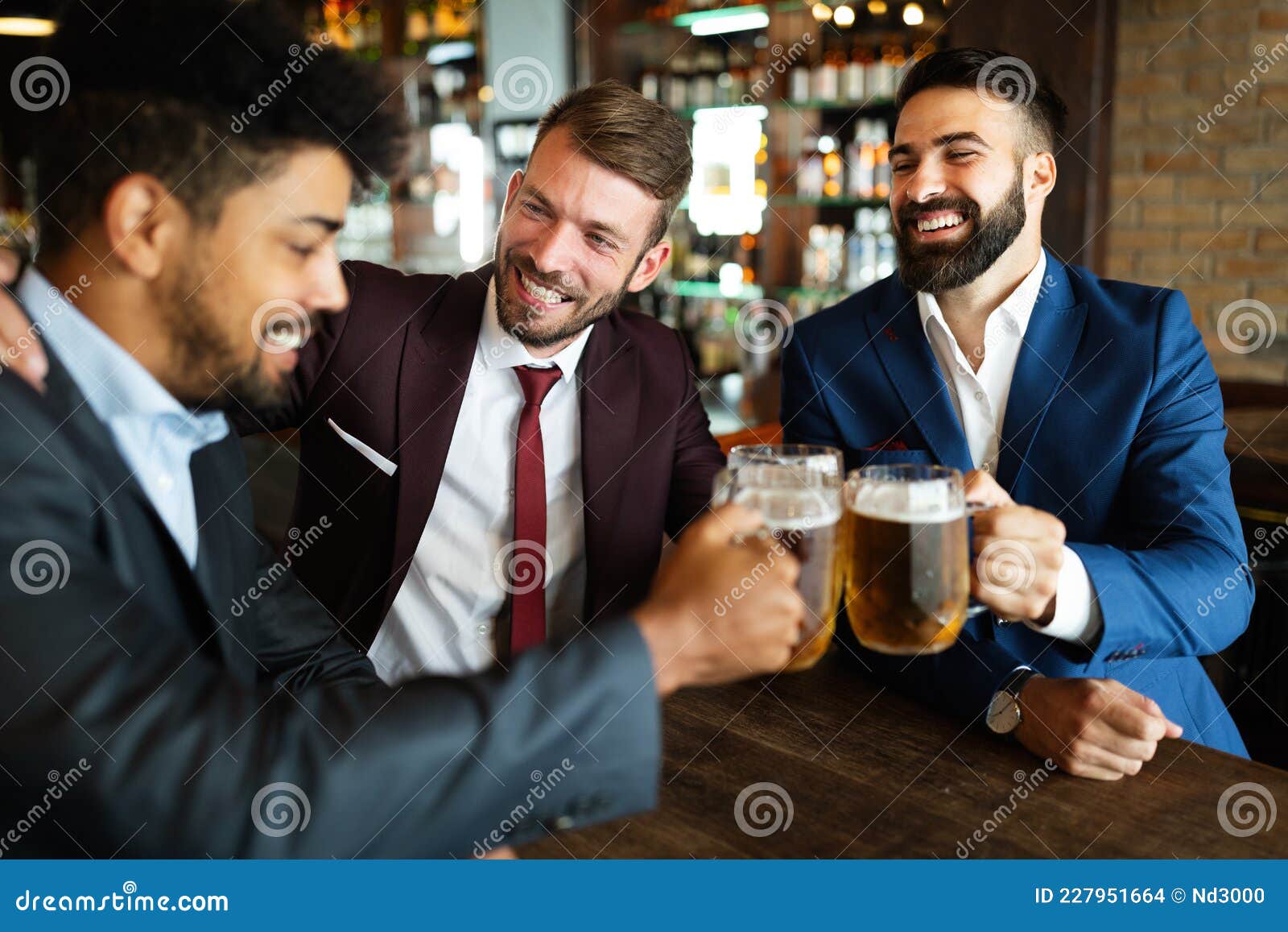 Team of Colleagues Socializing at the Bar and Drinking Beers Stock ...