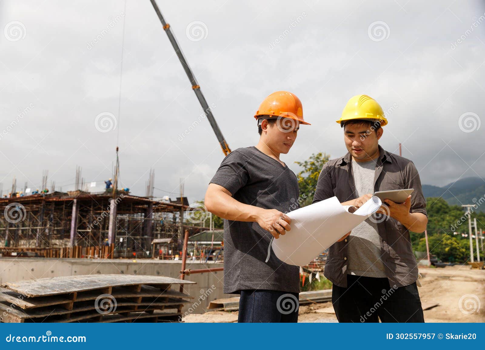 Team of Construction Workers Discussing Project Details with Blueprint ...