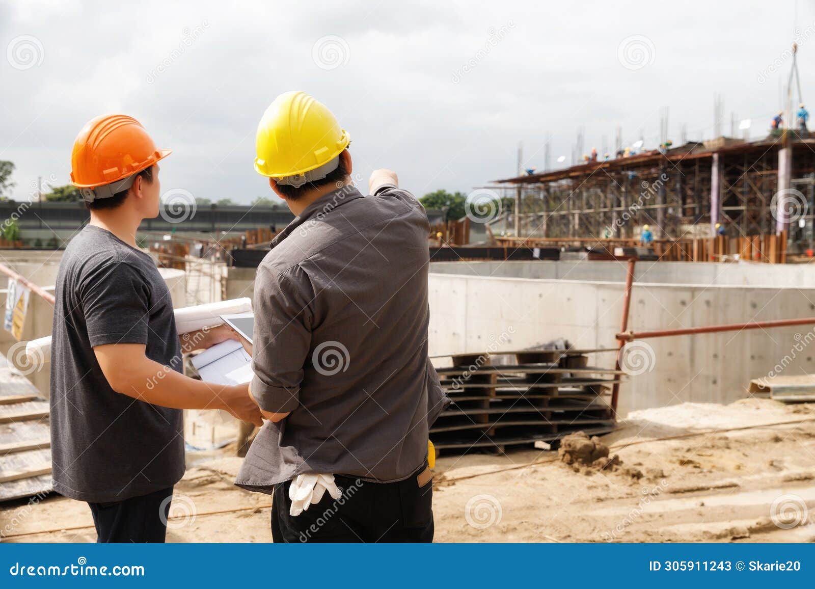 Team of Construction Workers Discussing Project Details with Blueprint ...