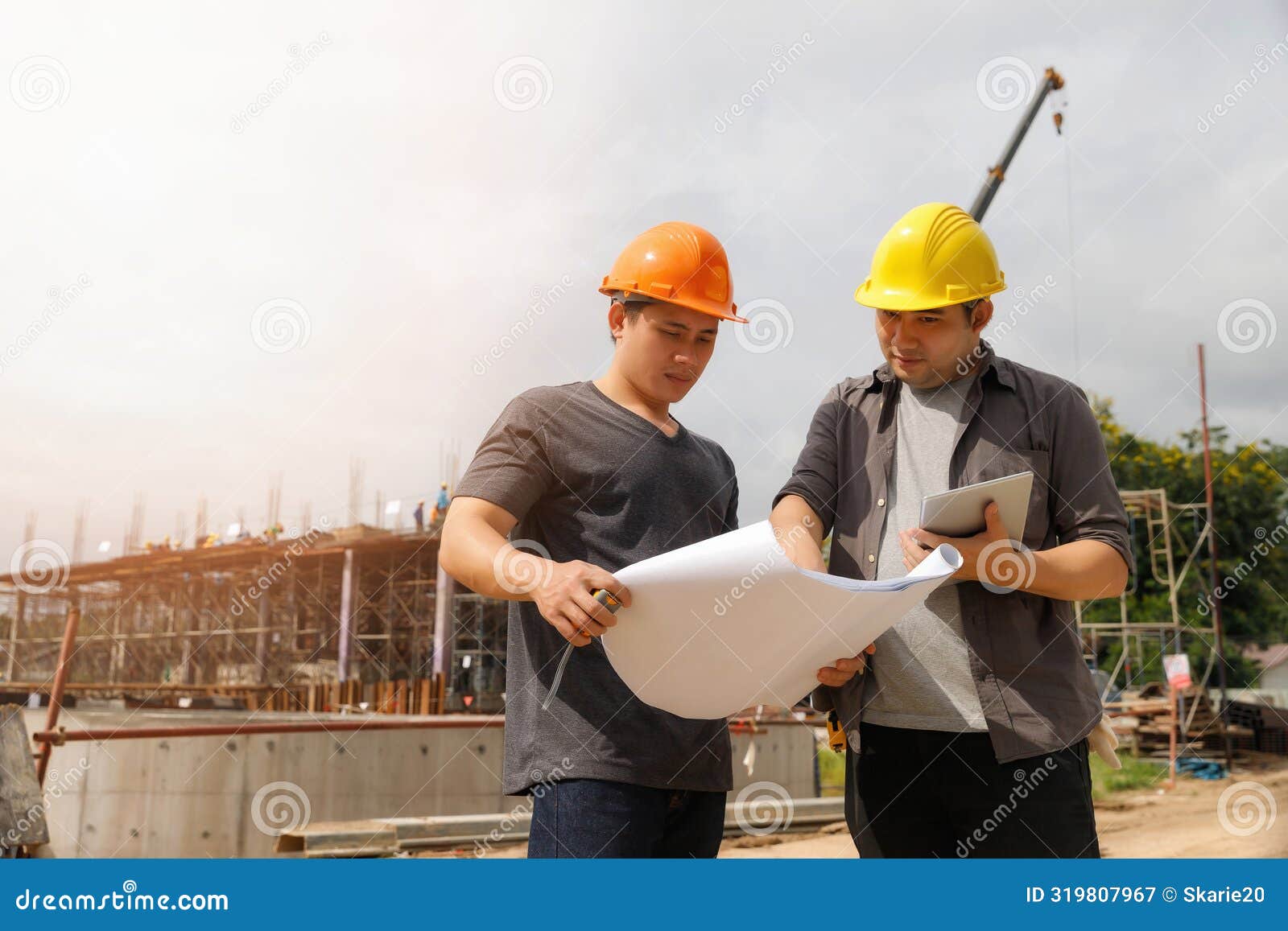 Team of Construction Workers Discussing Project Details with Blueprint ...