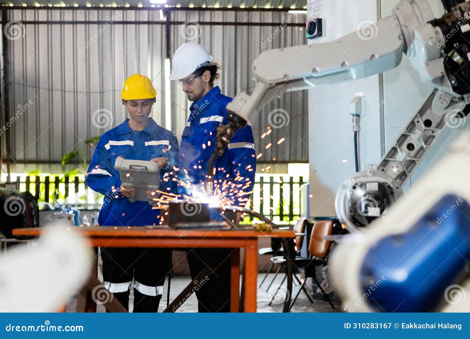 Team Engineer Using Remote Controller Steel Welding Robot Arm at ...