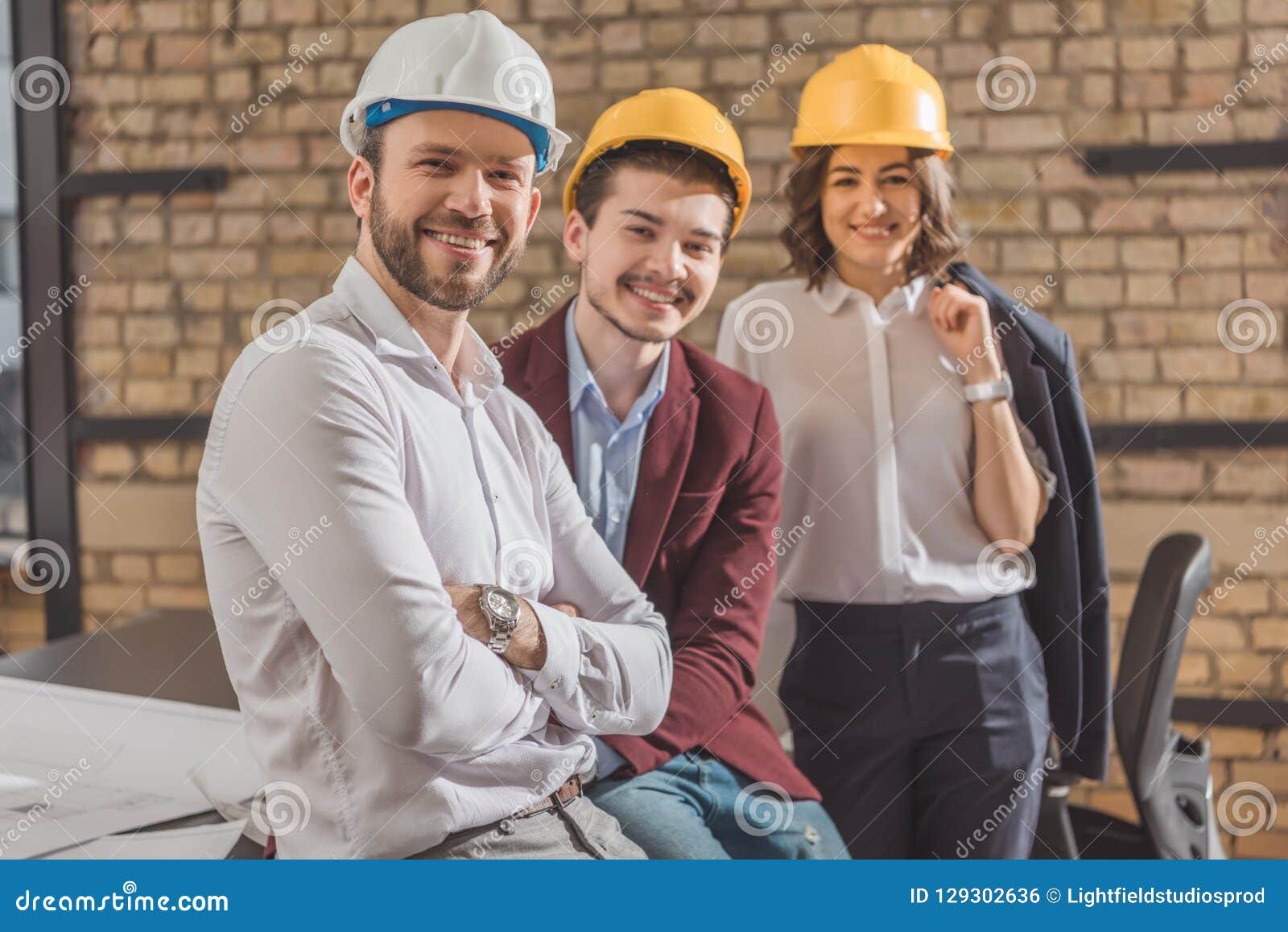 Team of Happy Architects in Hard Hats Looking Stock Photo - Image of ...