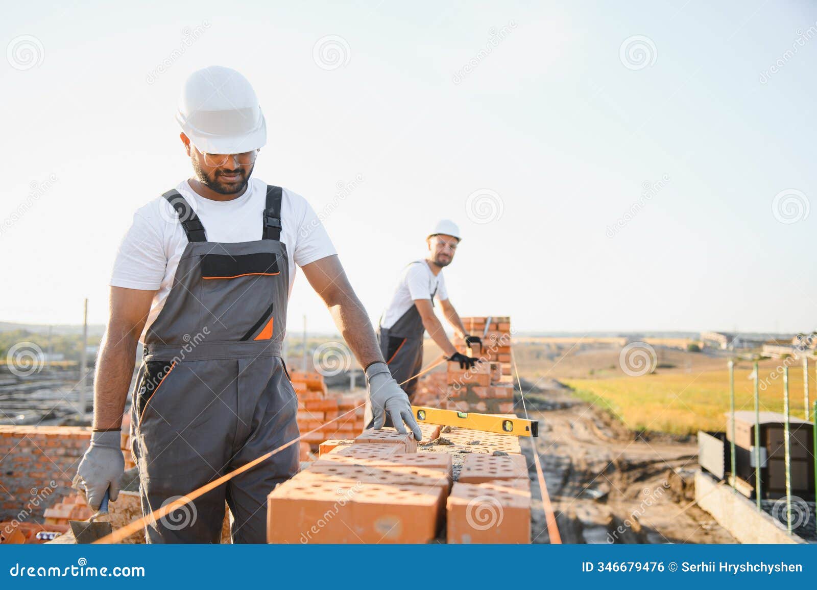 A Team of Indian Construction Workers in Overalls and Hard Hats are ...