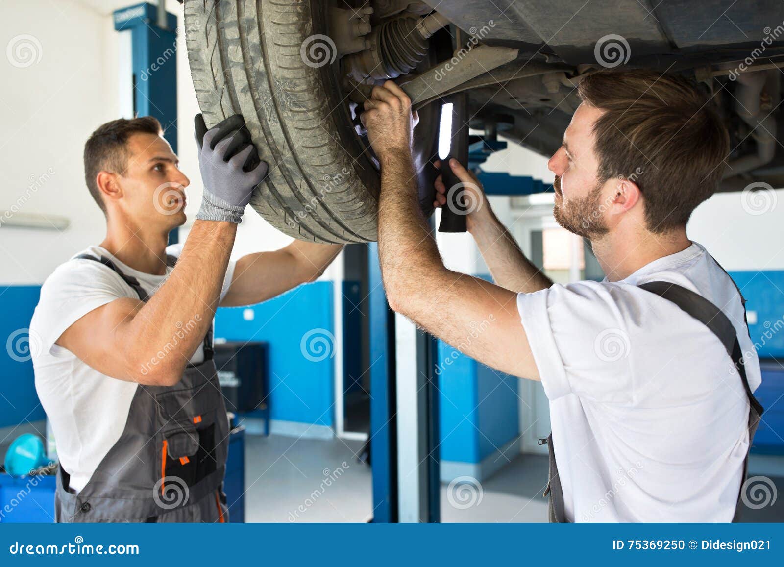 Team of Mechanics Repair Wheel on the Car Stock Photo - Image of male ...